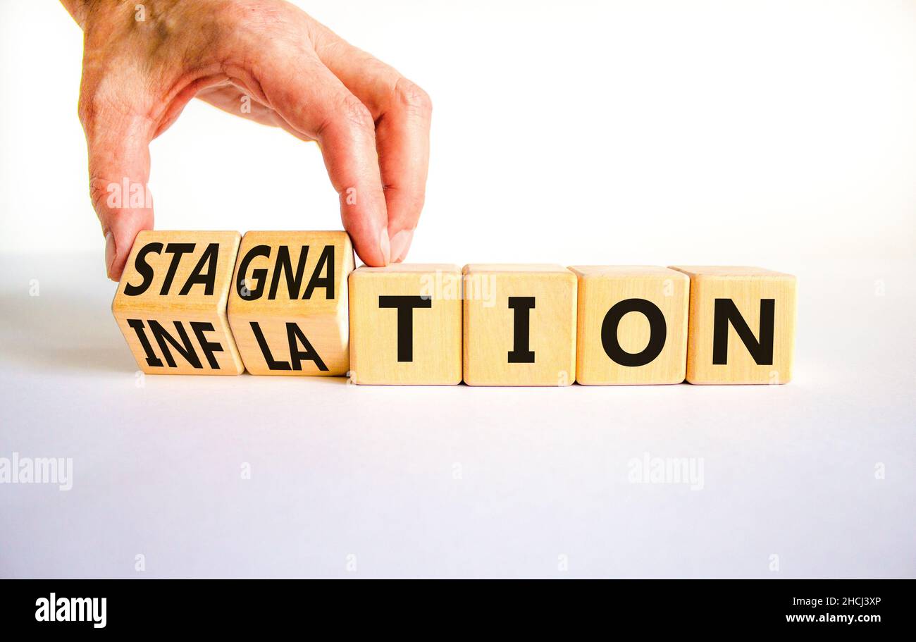 Inflation and stagnation symbol. Businessman turns cubes, changes the ...