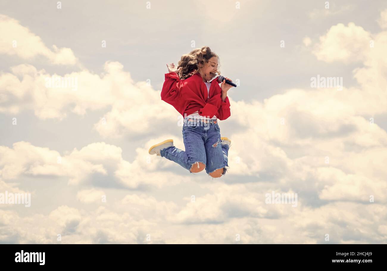 teen kid jumping and singing with microphone in karaoke. child singing ...