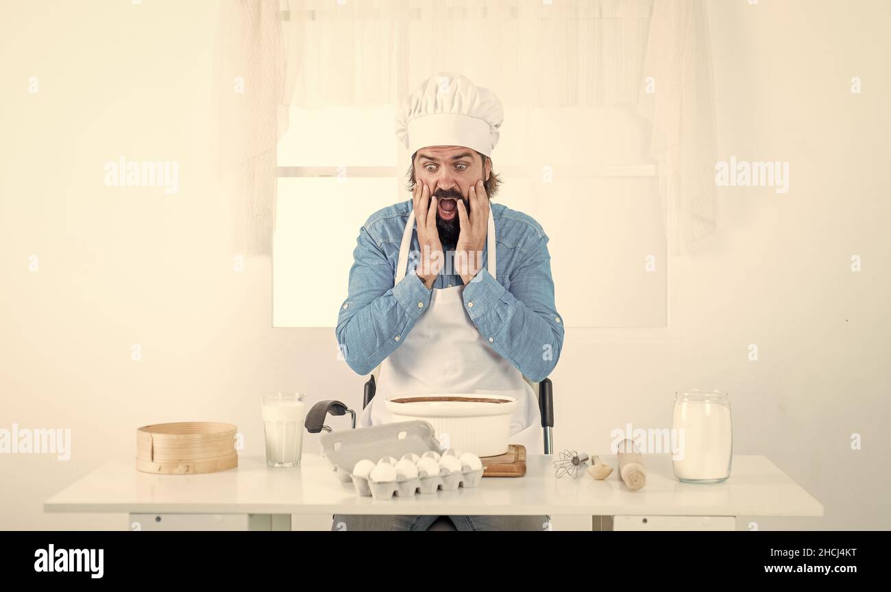 scared baker has some problems while cooking. male chef in hat prepare ...