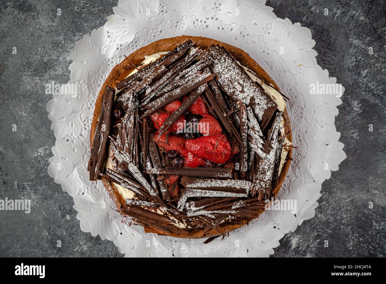 Top view of chocolate marquise cake with red berries resting on a ...