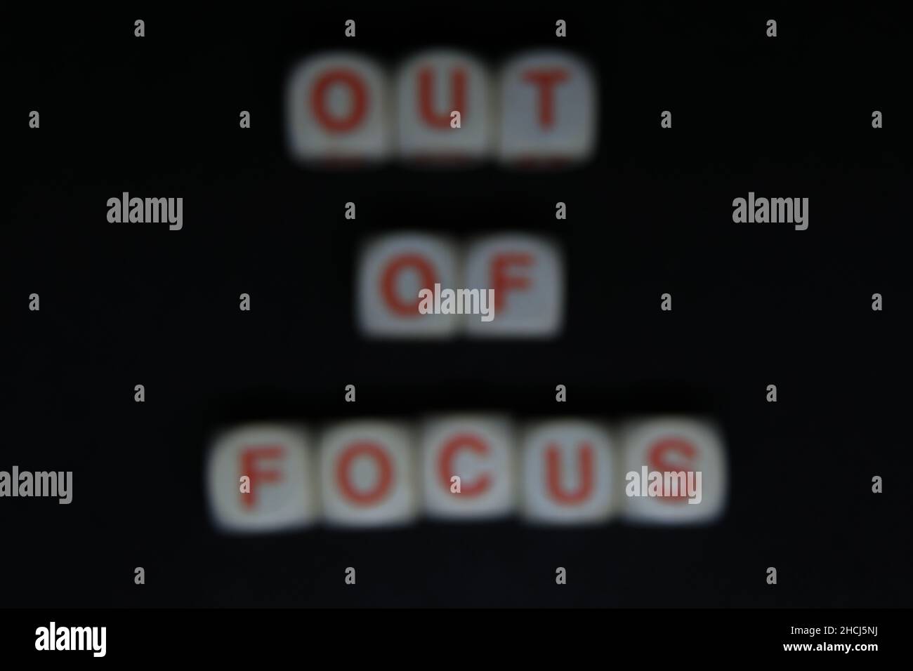 Wooden orange and white letters dice forming the writing OUT OF FOCUS ...