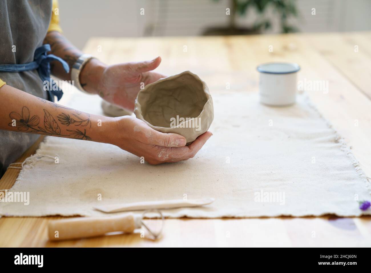 Woman potter sculpting clay pot with hand. Ceramist work with raw ...