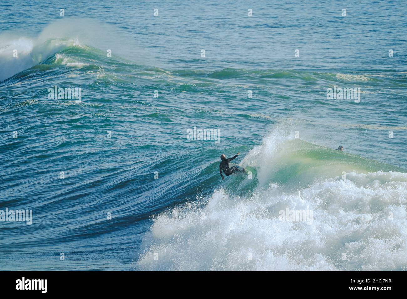Surfer riding a blue ocean wave on his surfboard Stock Photo - Alamy