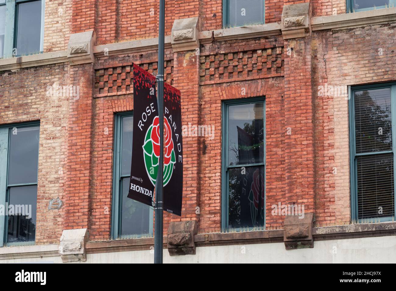 Sign announcing the upcoming 2022 Rose Parade shown against a brick ...