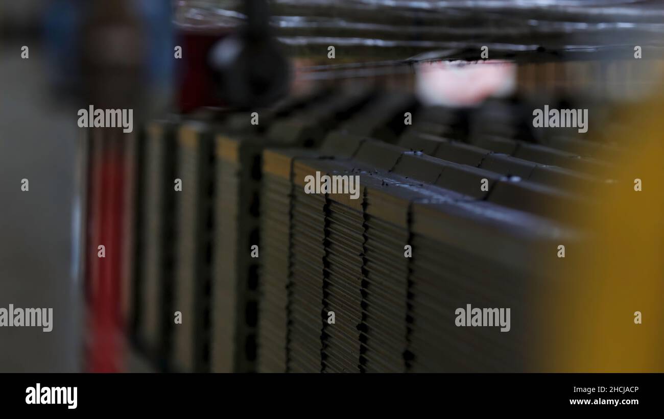 Industrial background with raw ceramic blocks being cut by saw string ...