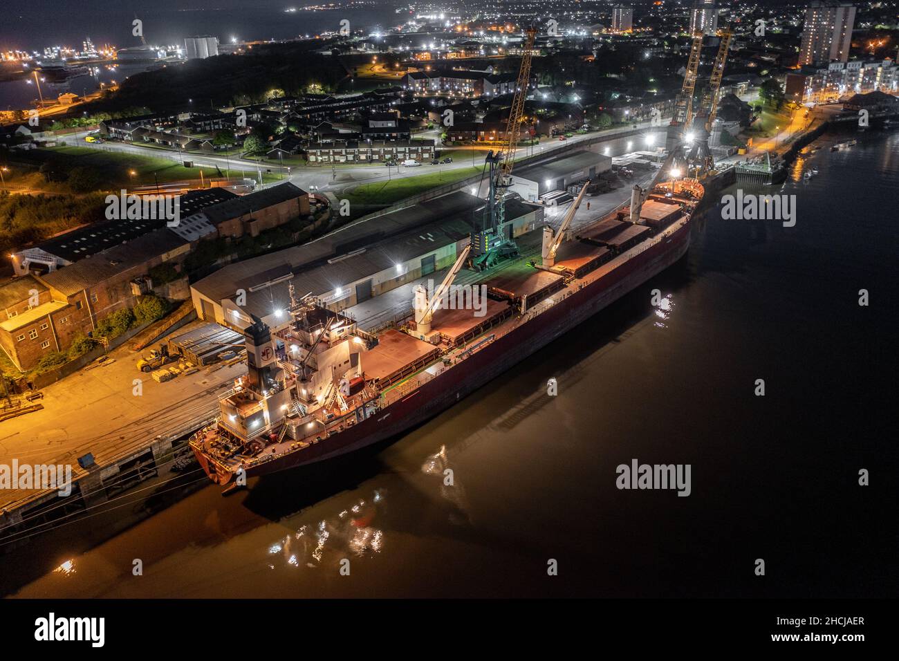 Ship Offloading Cargo at Docks at Night Stock Photo - Alamy