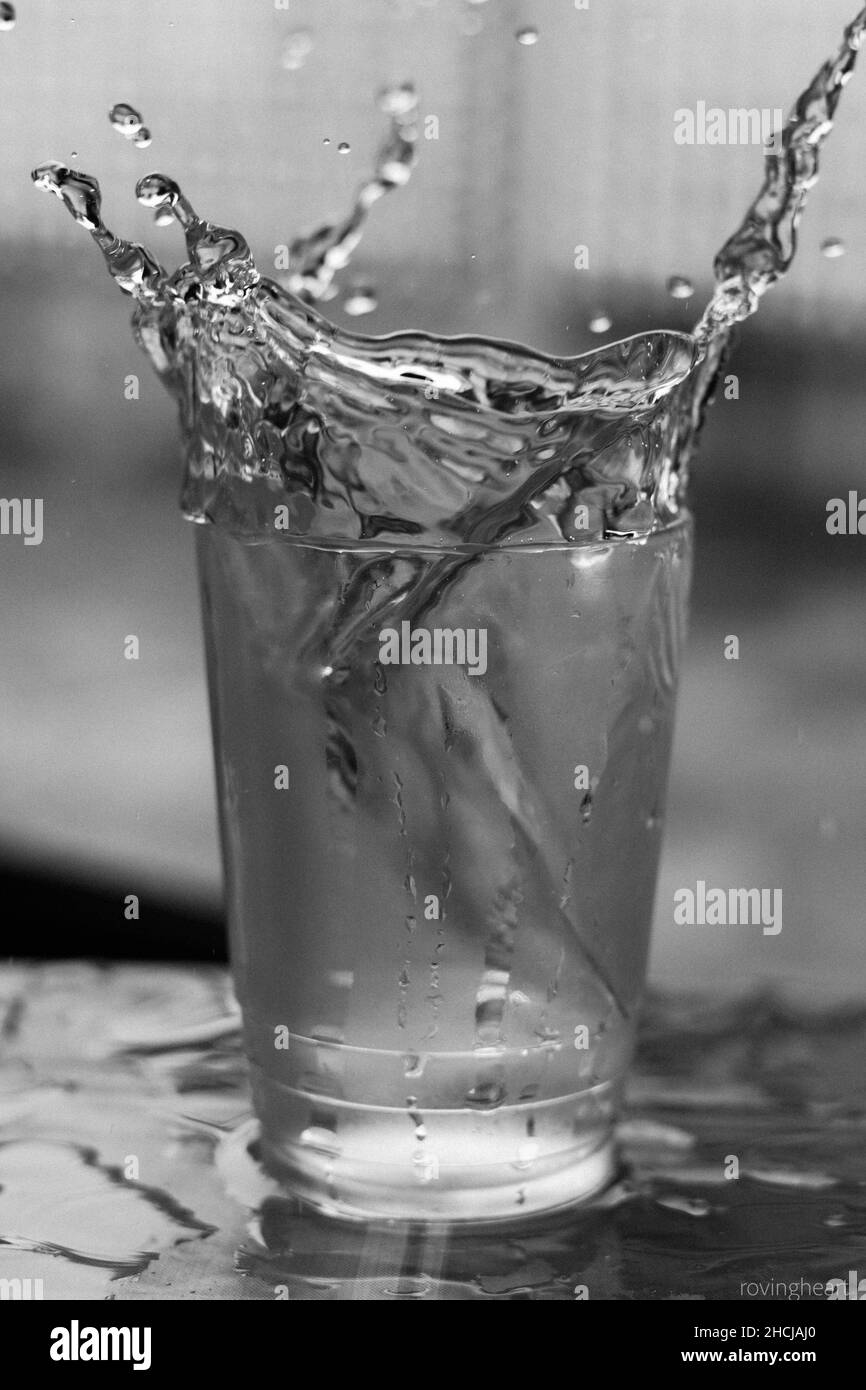 Vertical shot of water splashing into a transparent glass Stock Photo ...
