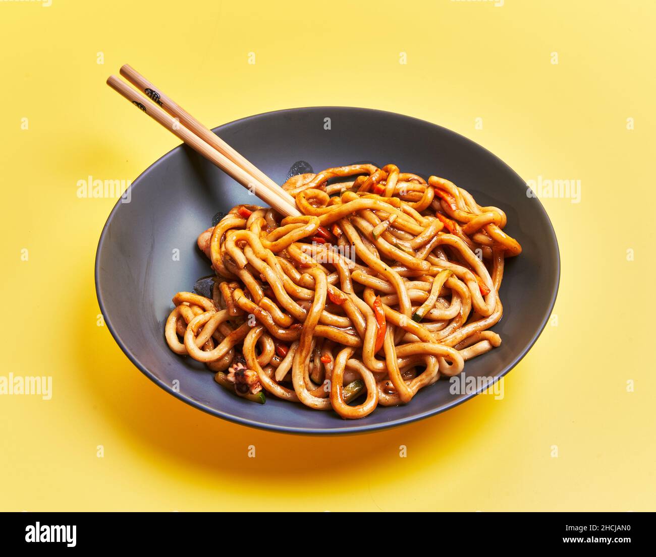 Plate of delicious noodles over yellow background Stock Photo - Alamy