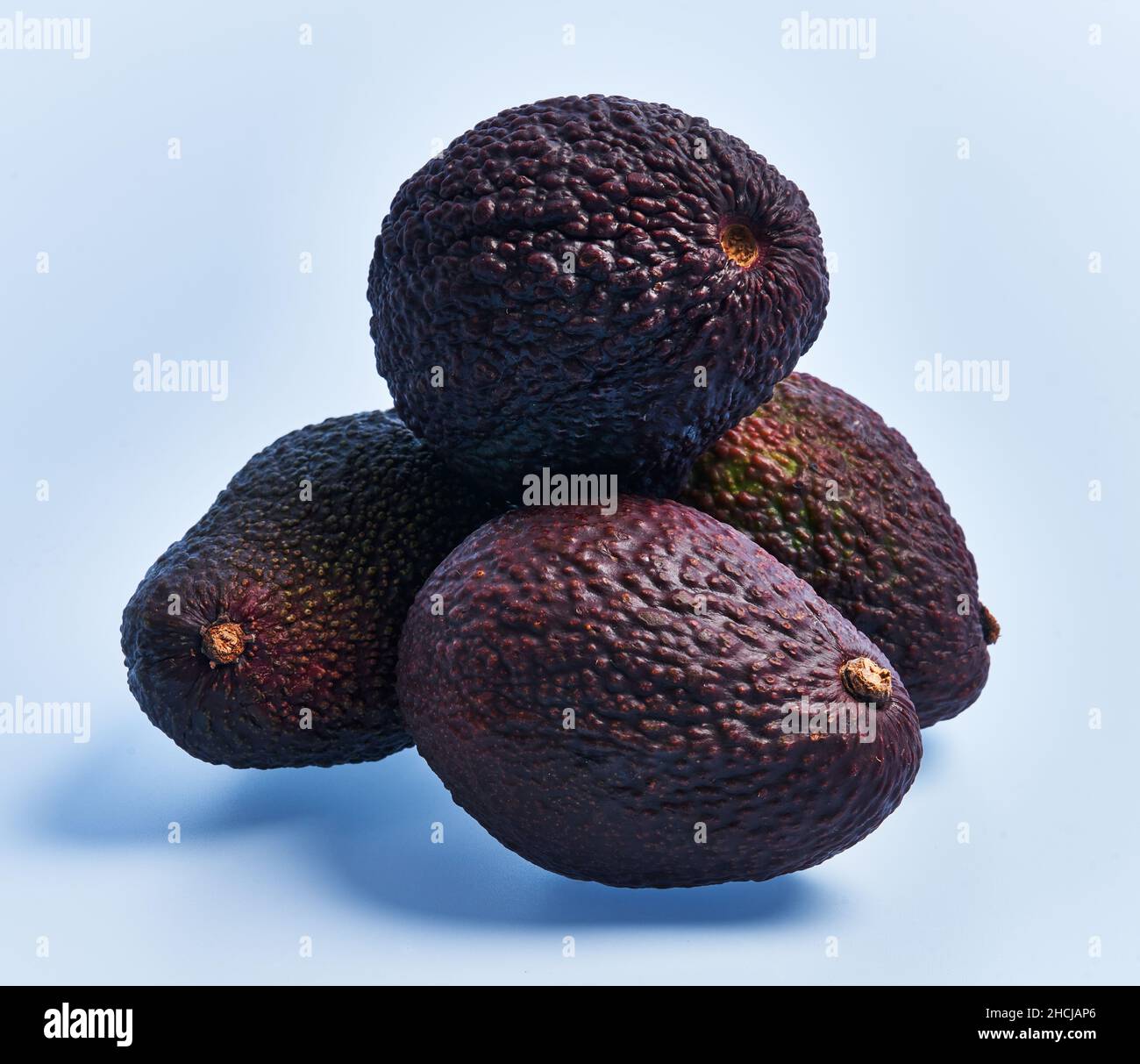 Group of avocados fruit over blue background Stock Photo - Alamy