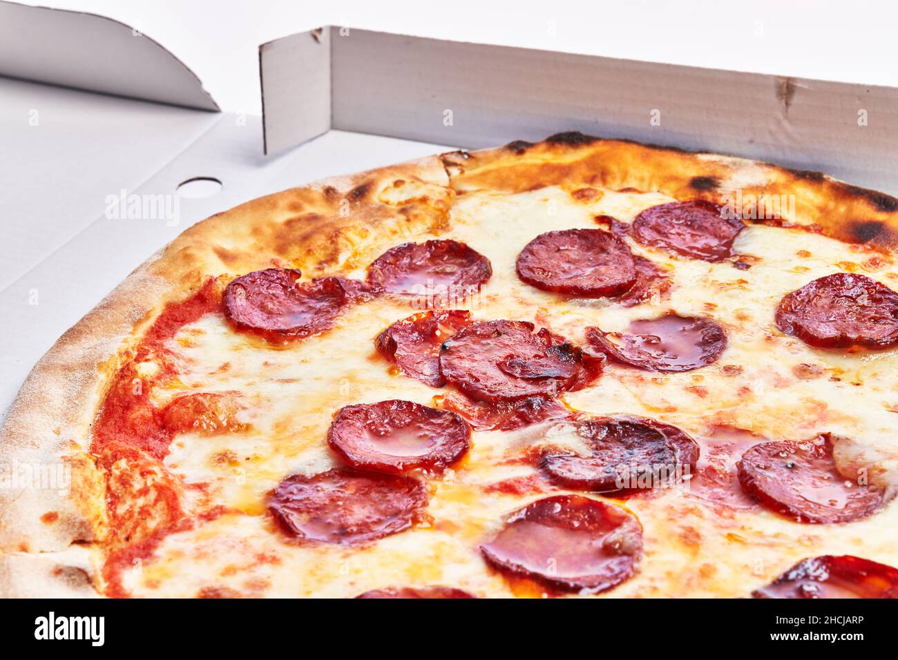 Single pepperoni italian pizza on delivery box isolated over white ...