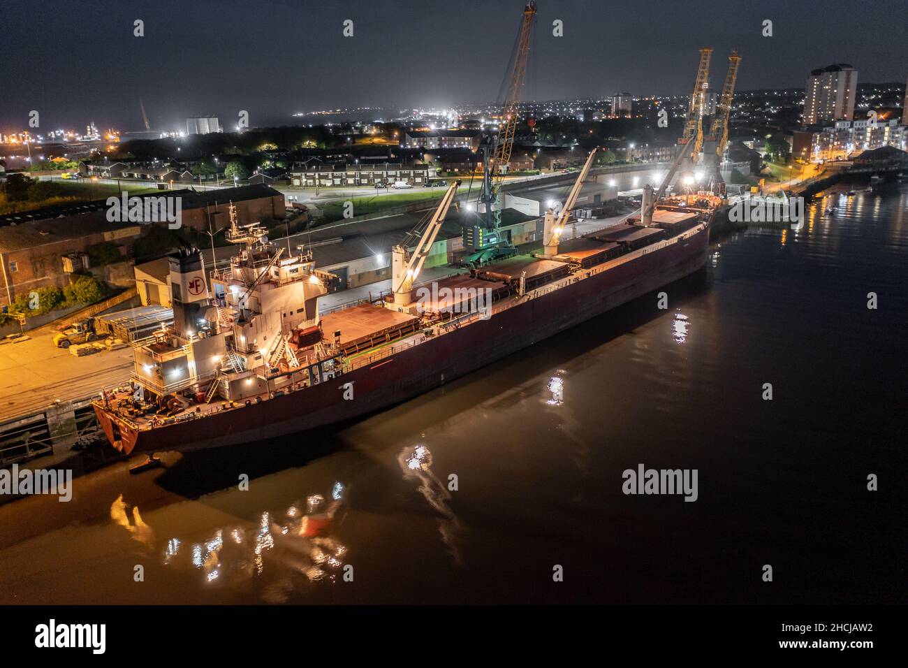 Ship Offloading Cargo at Docks at Night Stock Photo - Alamy
