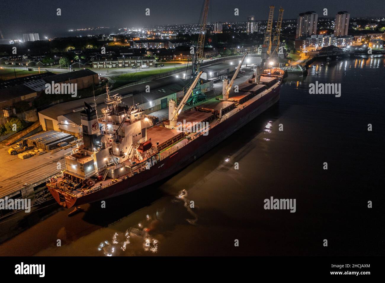Ship Offloading Cargo at Docks at Night Stock Photo - Alamy