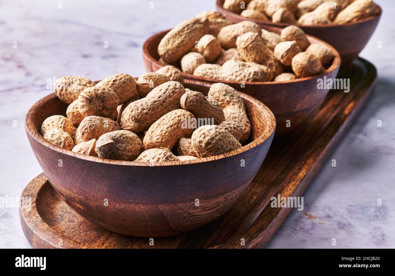 Bowls of peanuts with shell on a marble surface Stock Photo - Alamy