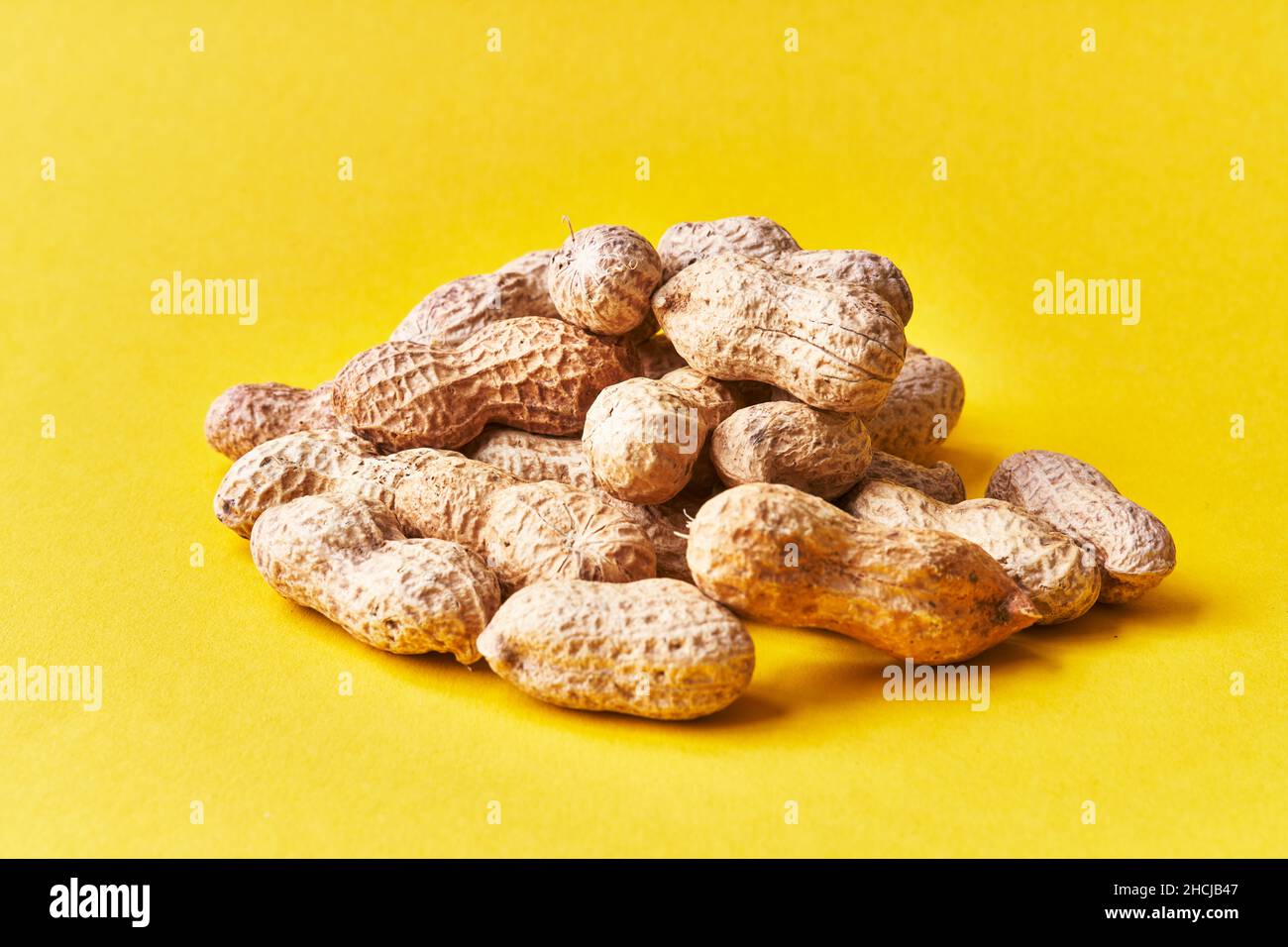 Bunch of peanuts with shell on a yellow background Stock Photo - Alamy