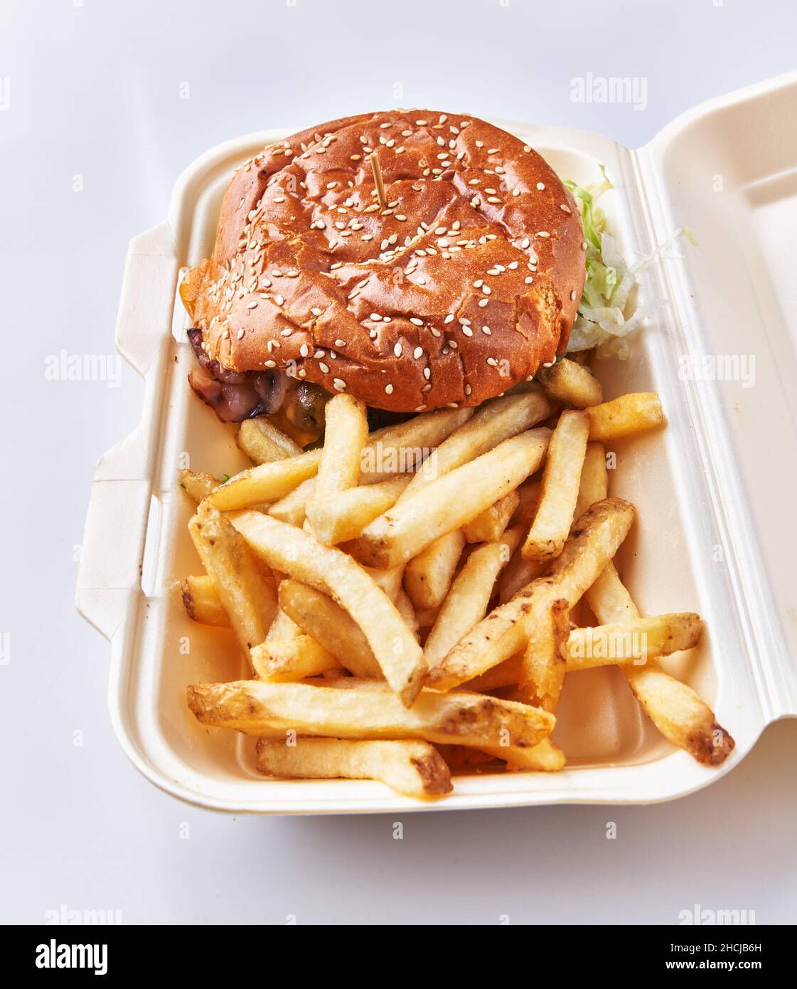 Delivery classical hamburger with chips potatoes isolated on a white ...