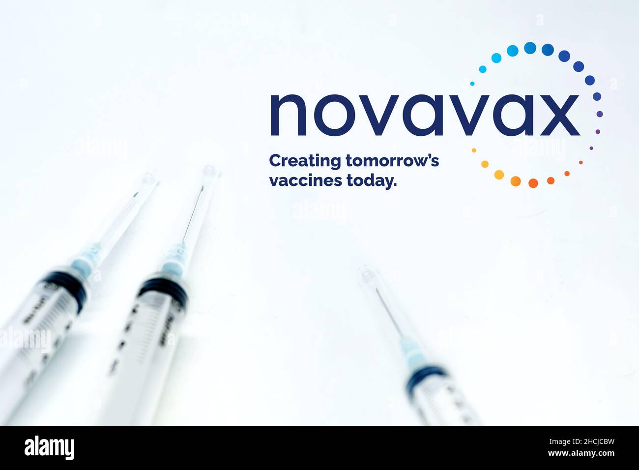 New York, USA, December 2021: three syringe next to the Novavax logo ...
