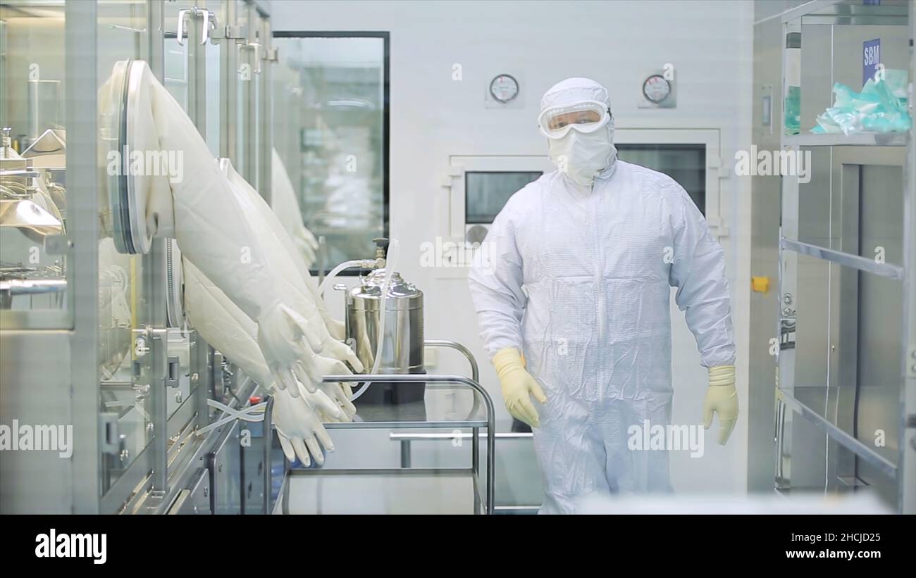 Worker at pharmaceutical factory operating control panel of the ...