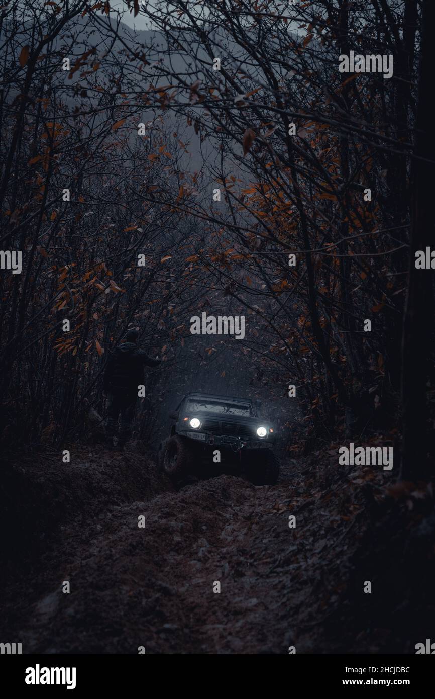 Off-road black car driving in the dark forest Stock Photo - Alamy