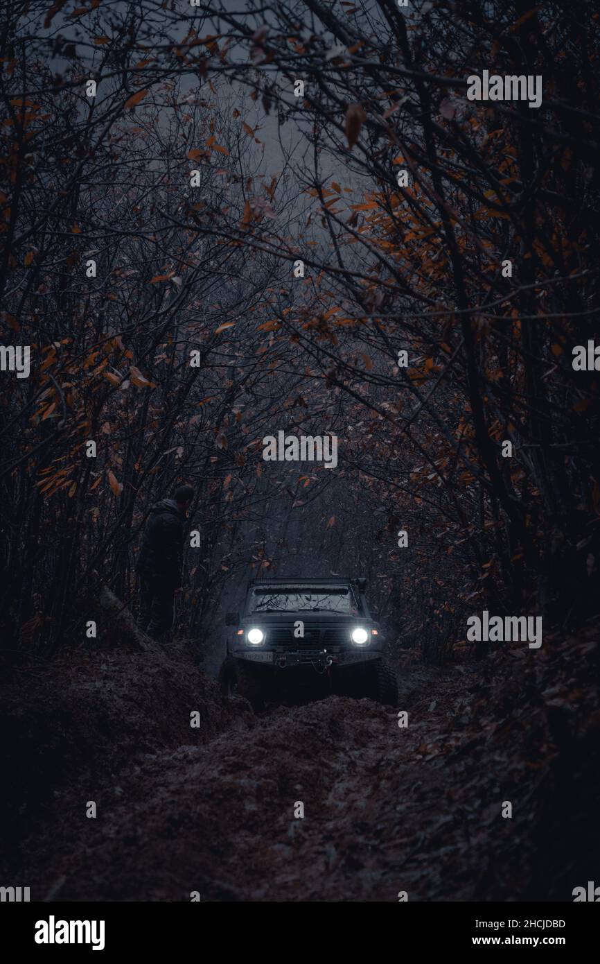 Off-road black car driving in the dark forest Stock Photo - Alamy