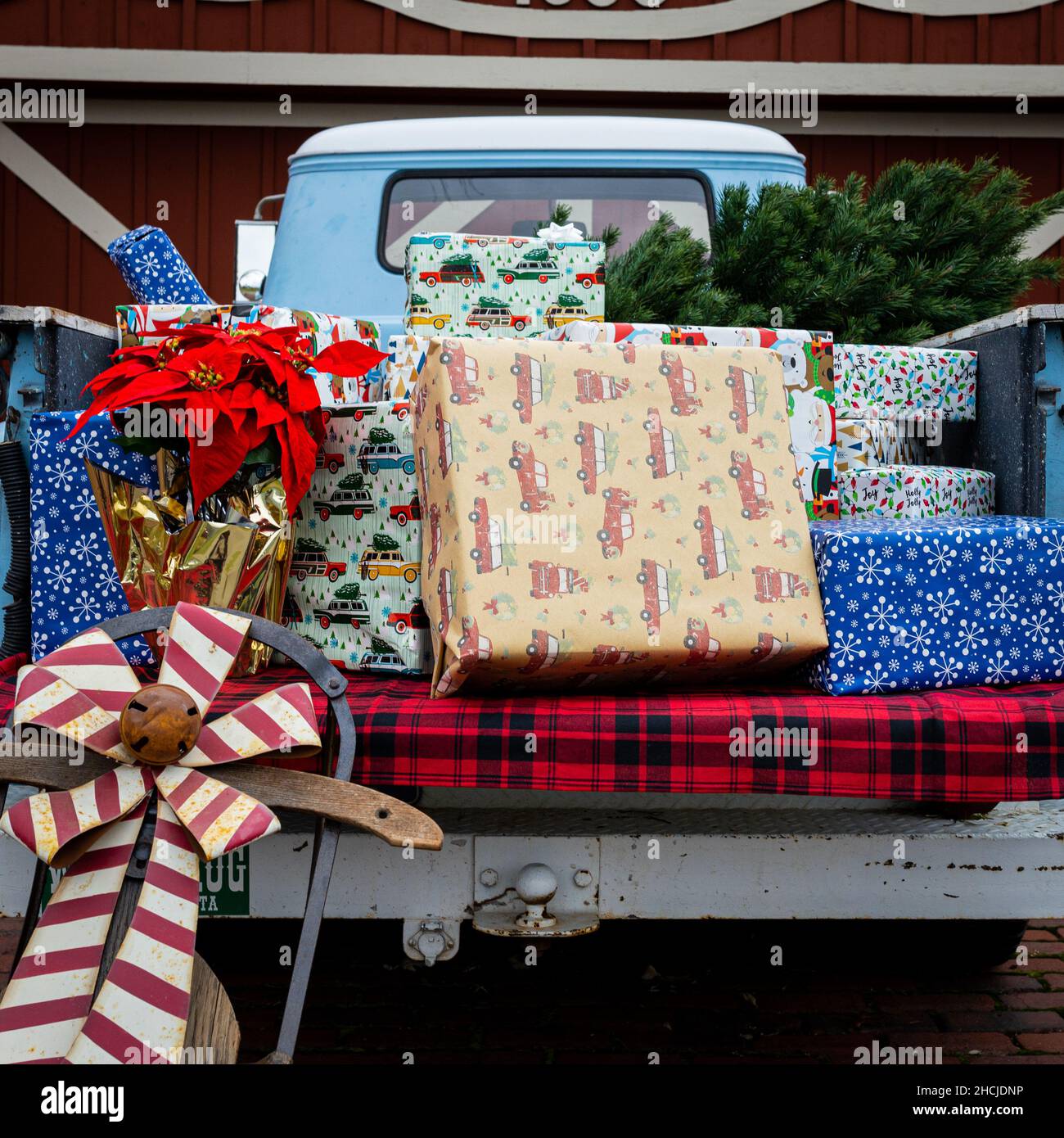 Closeup of a blue truck filled with Christmas gift boxes and a tree in ...