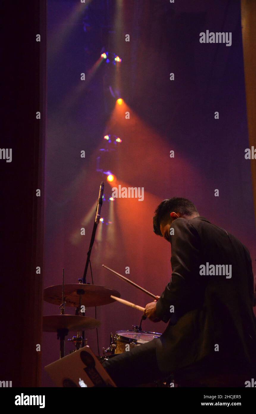 Closeup of a drummer performing on stage in Christ University against ...