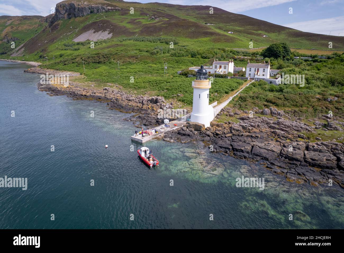 Small Red Ferry Arriving at a Remote Lighthouse Stock Photo - Alamy