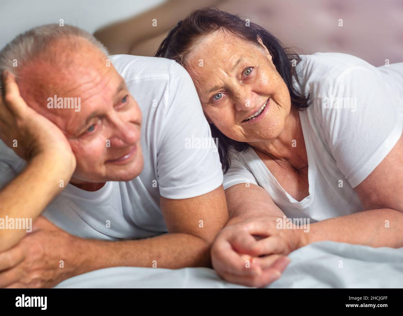 Senior couple lie on the couch and look out the window retired Stock ...