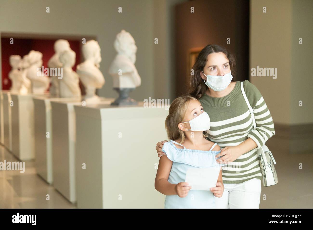 Woman visitor with daughter looking at exhibition in museum Stock Photo ...