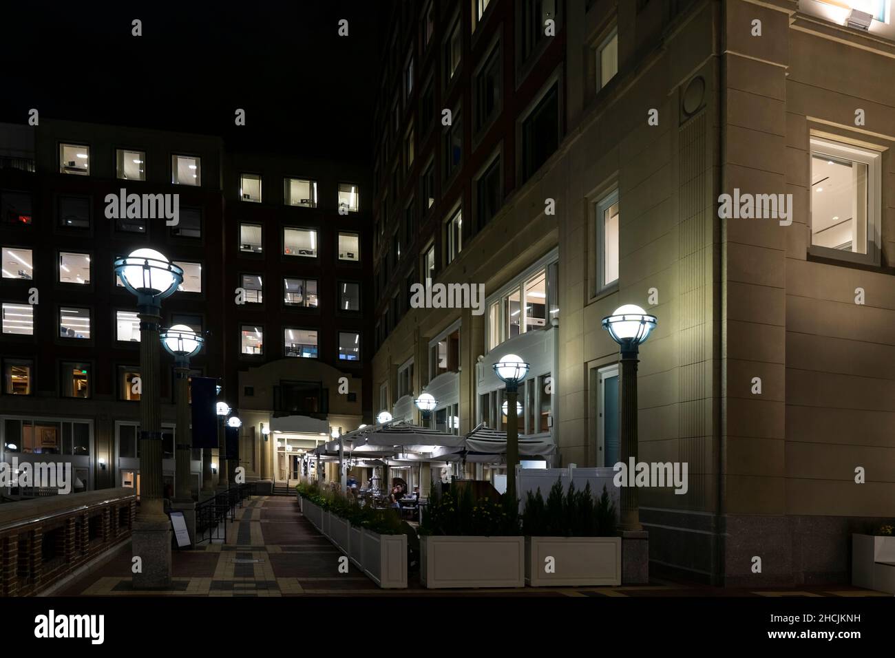 Outdoor eating space of a restaurant at night. Lights around restaurant ...