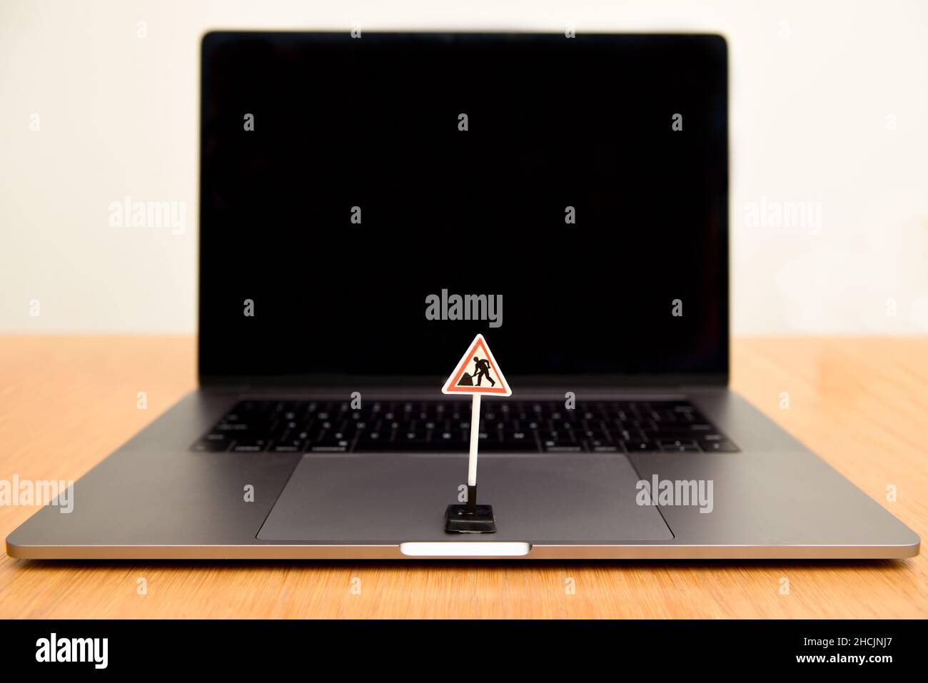 Website under construction sign in front of blank page of computer ...