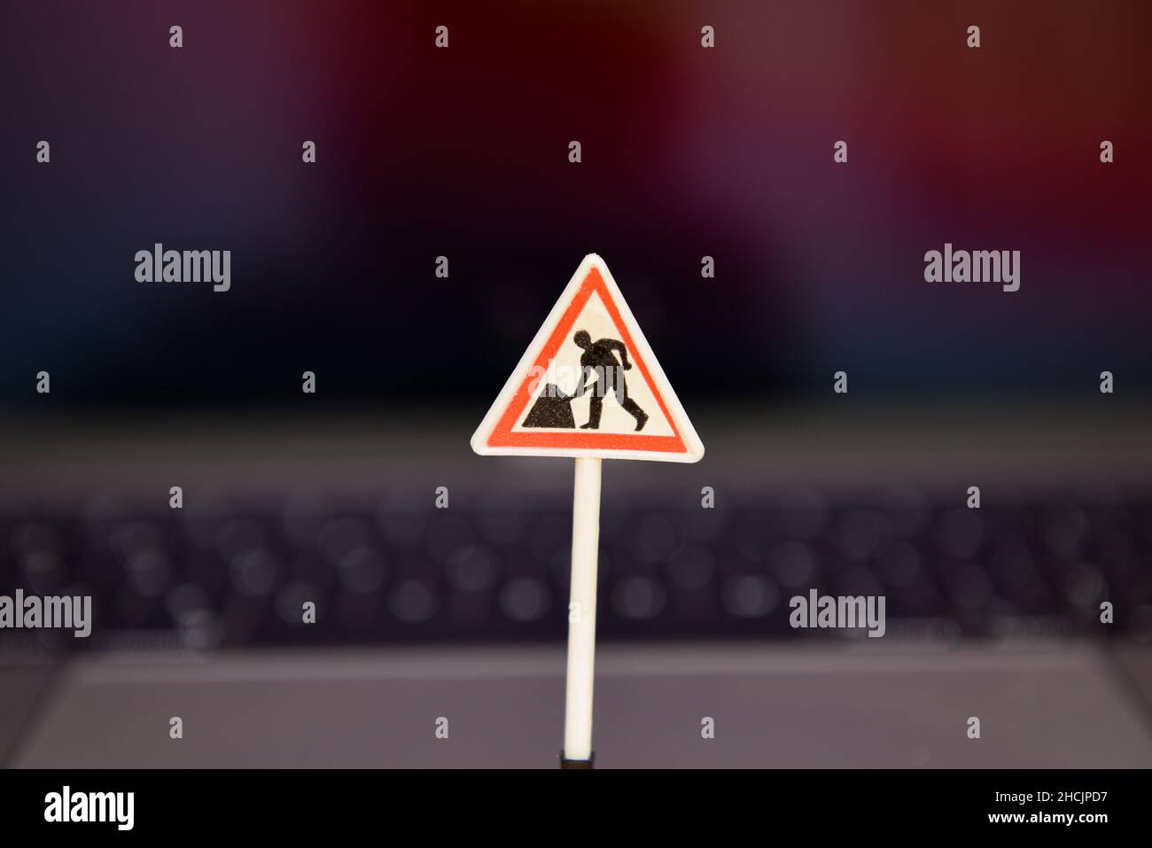 Website under construction sign in front of blank page of computer ...