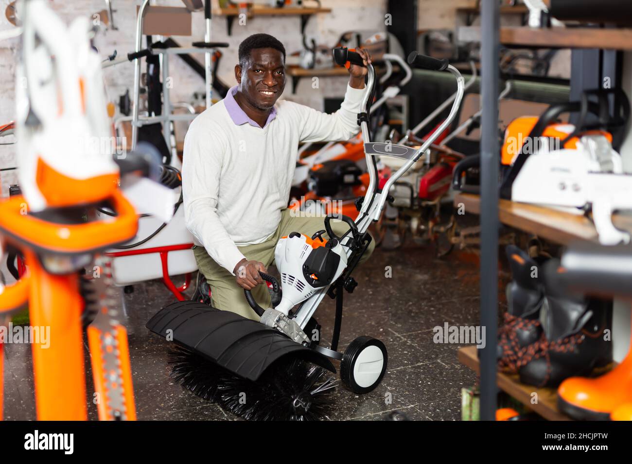 Customer takes close look at new street sweeper at tool store Stock ...