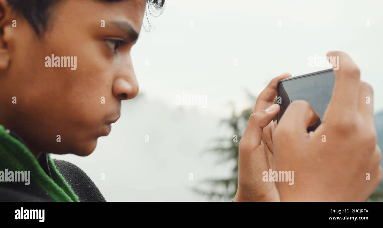 Side profile of an Indian boy angry playing on the phone Stock Photo ...