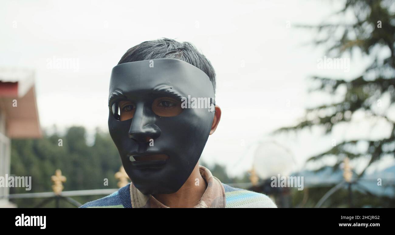 Portrait of a young Indian boy wearing a black funny face mask Stock ...