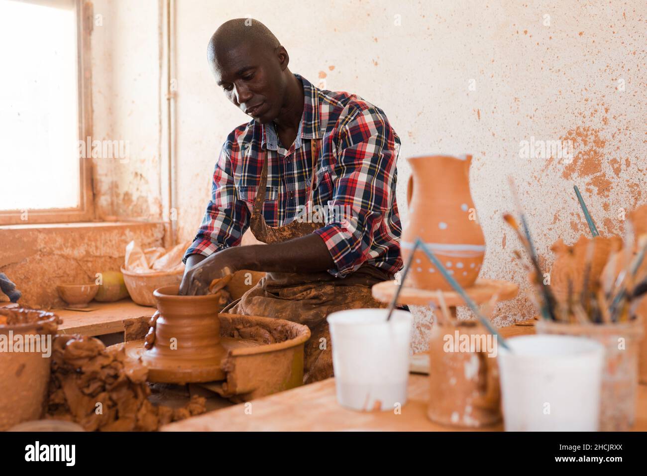 Man creating earthenware on wheel hi-res stock photography and images ...
