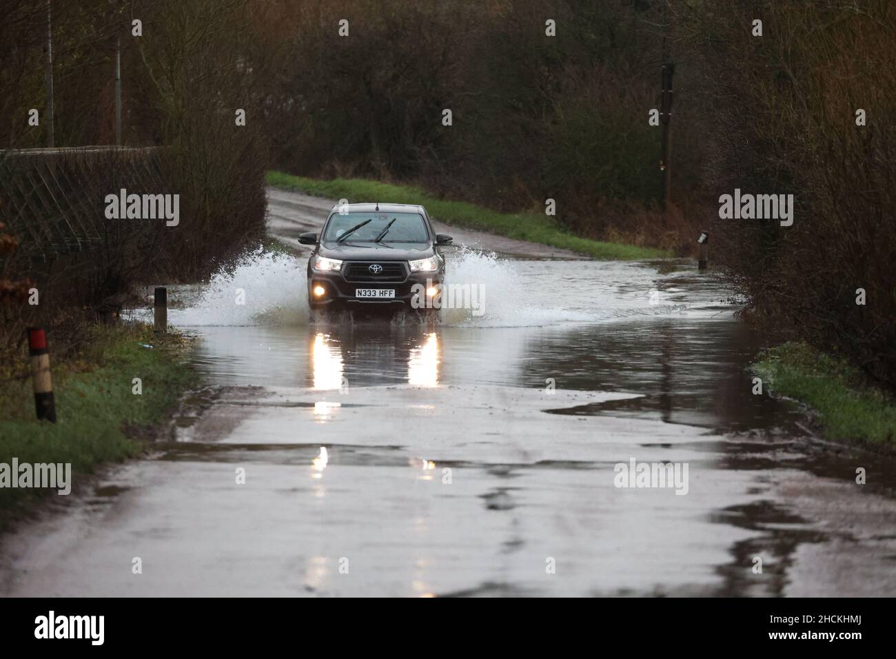 Sutton Gault, UK. 28th Dec, 2021. A vehicle gets through the flooded ...