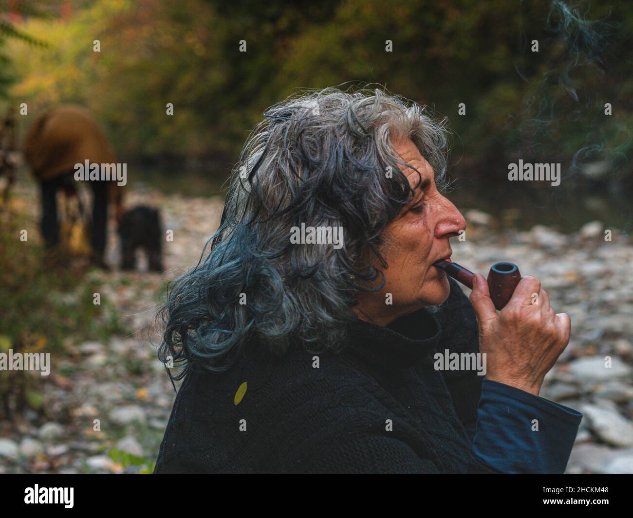 Senior lady with gray hair smoking a pipe Stock Photo - Alamy