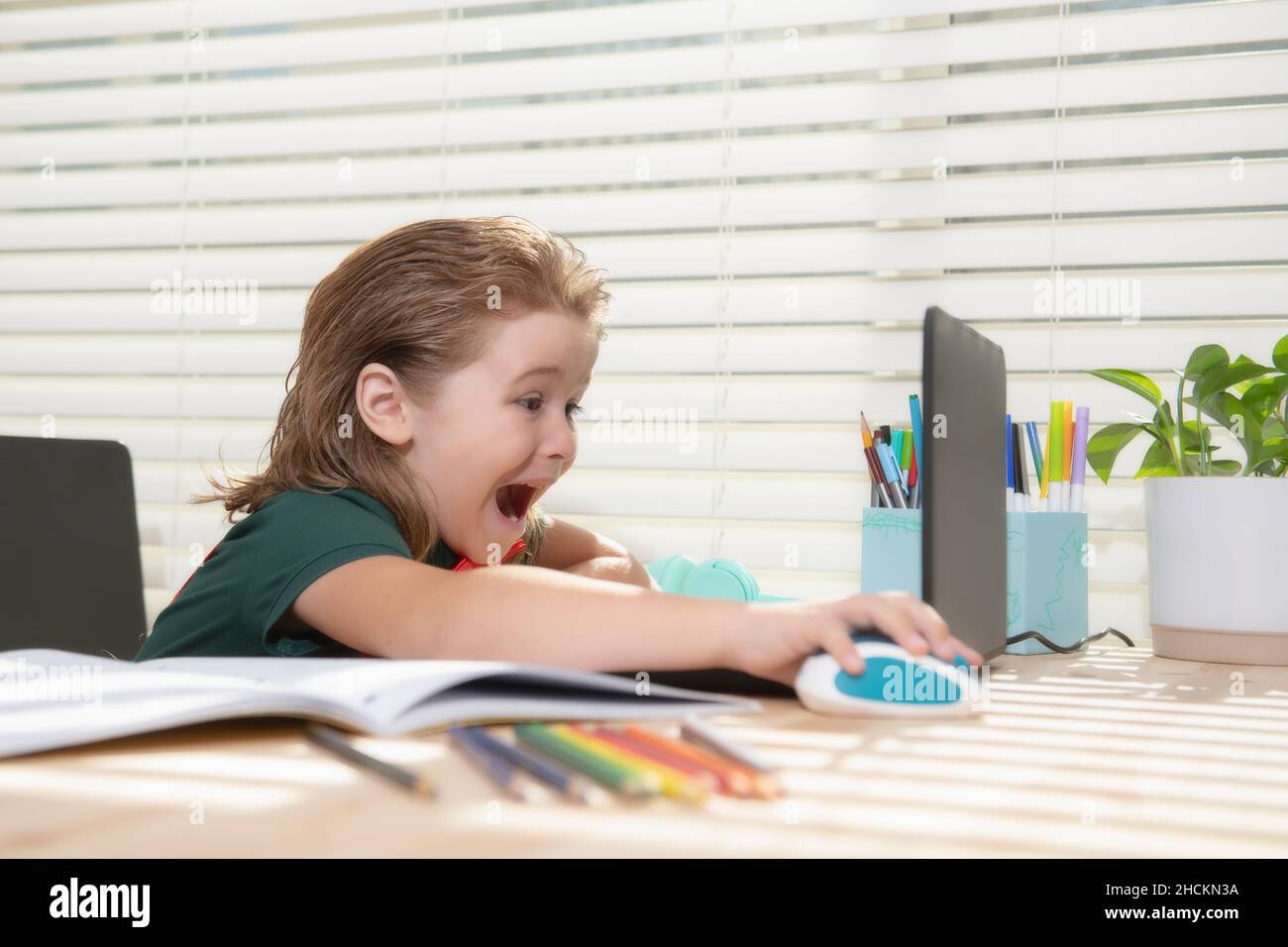 Smart school boy at home writing homework. Little student with notebook ...