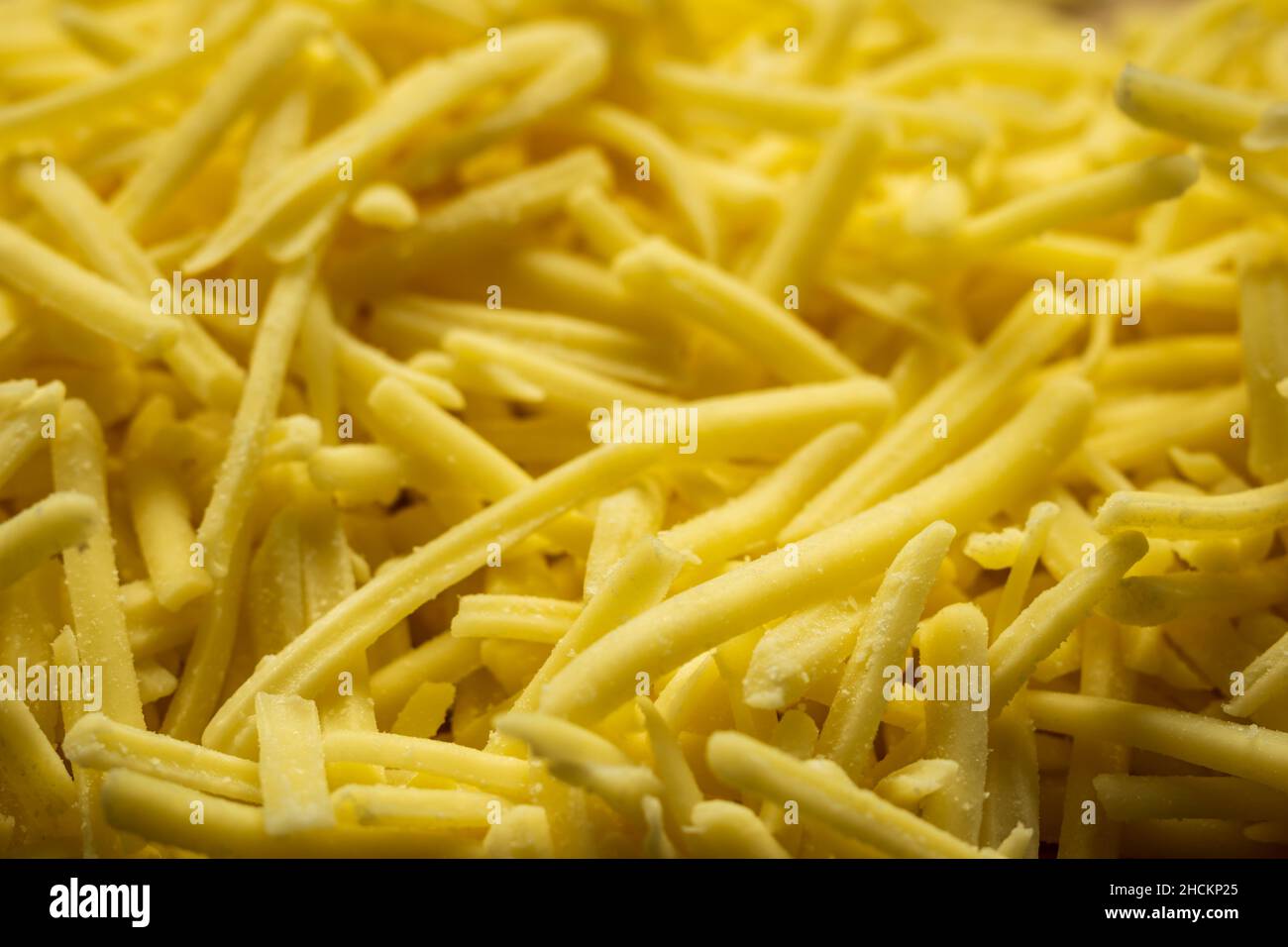 grated cheddar cheese background closeup Stock Photo - Alamy