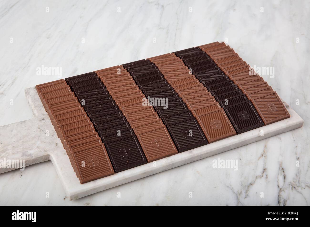 Bitter square madlen chocolates on marble background. Milky and bitter ...