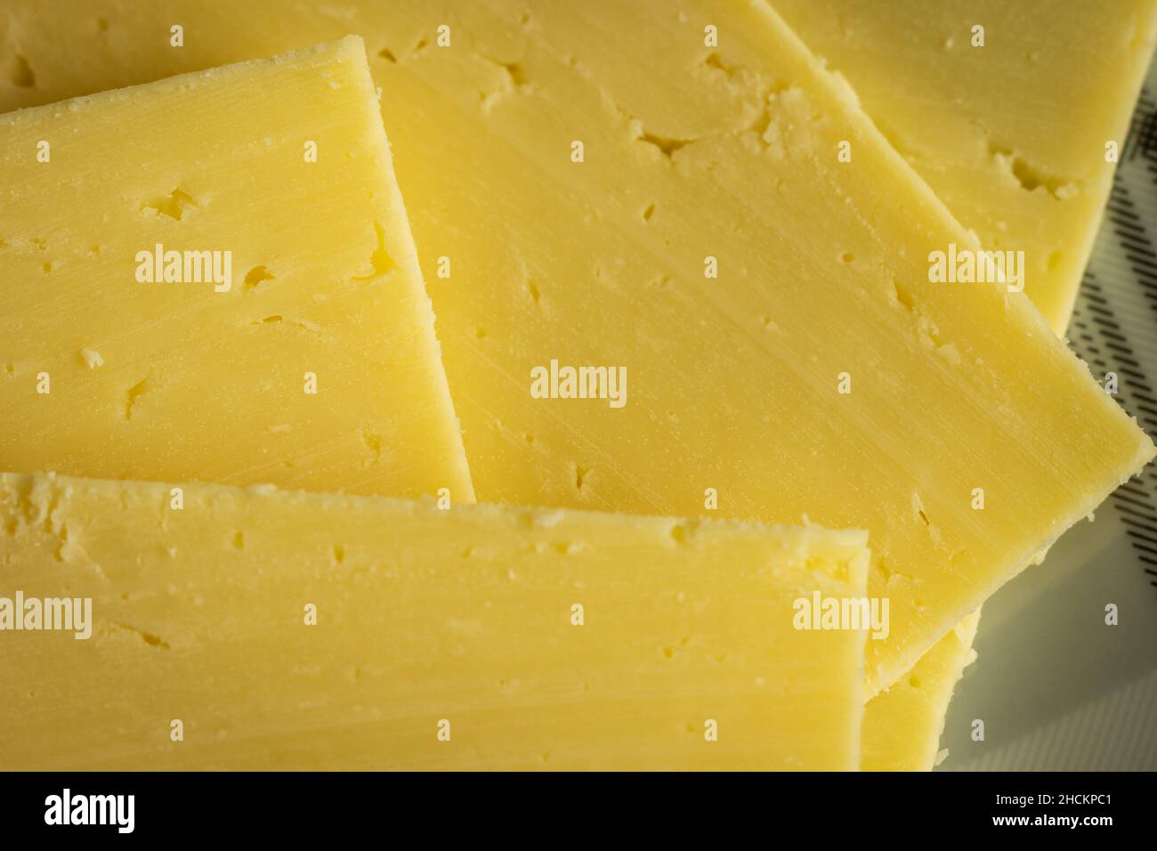 cheddar cheese slices on plate closeup Stock Photo - Alamy