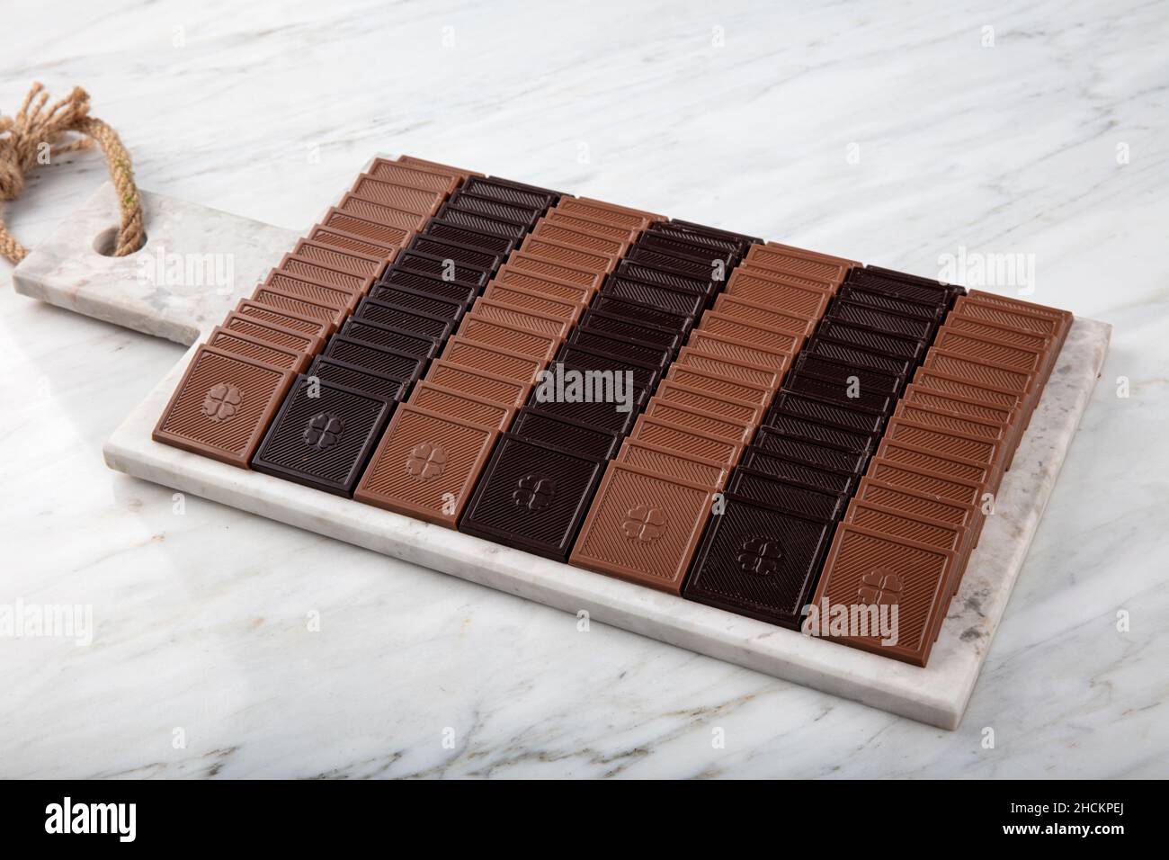 Bitter square madlen chocolates on marble background. Milky and bitter ...