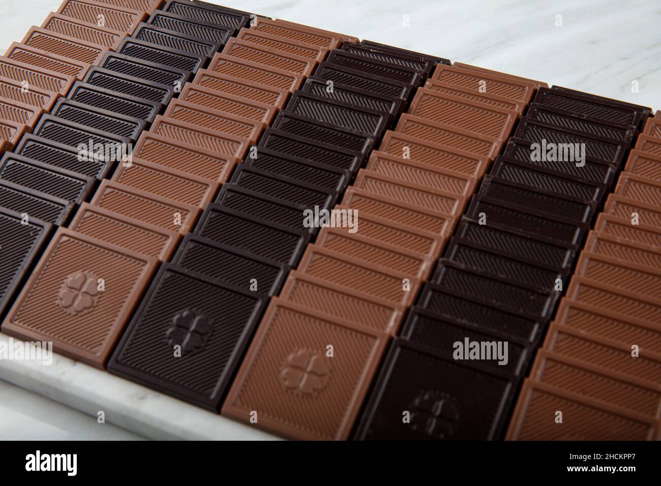 Bitter square madlen chocolates on marble background. Milky and bitter ...