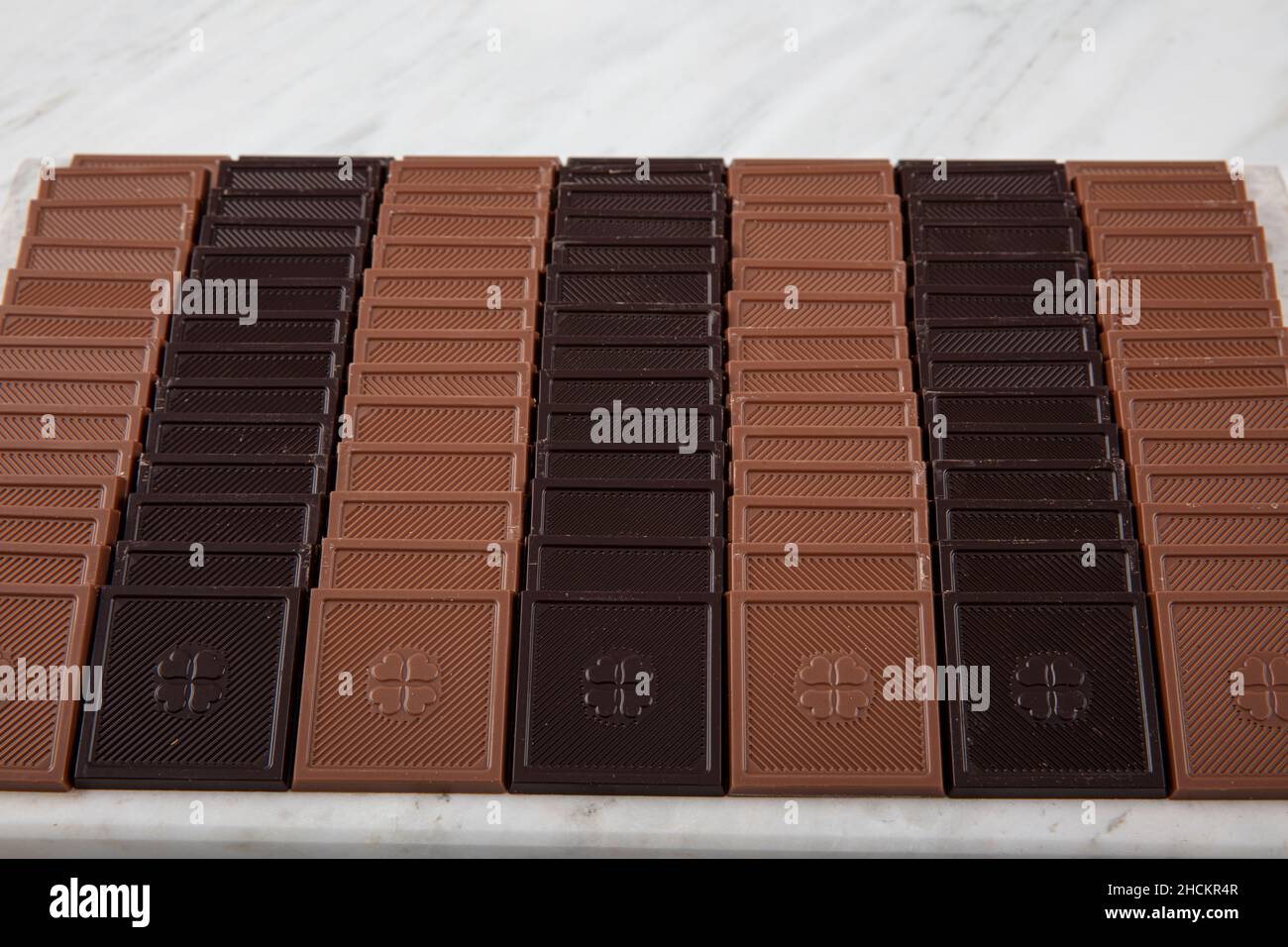 Bitter square madlen chocolates on marble background. Milky and bitter ...