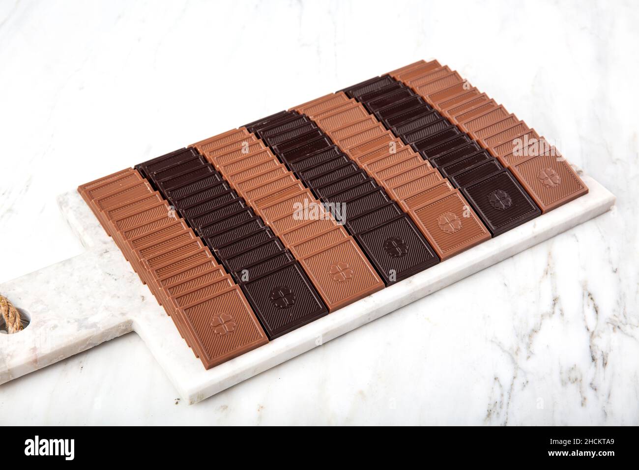Bitter square madlen chocolates on marble background. Milky and bitter ...
