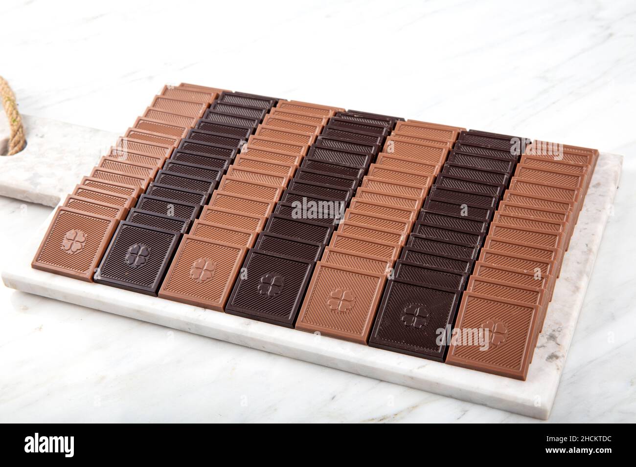 Bitter square madlen chocolates on marble background. Milky and bitter ...