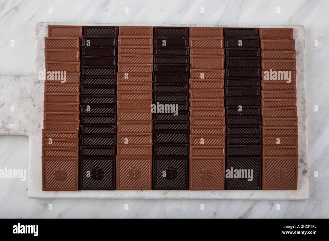 Bitter square madlen chocolates on marble background. Milky and bitter ...