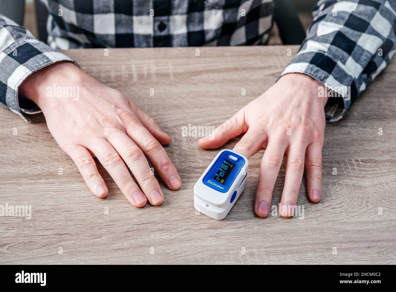 A man checking oxygen level at home with home oximeter, patient ...