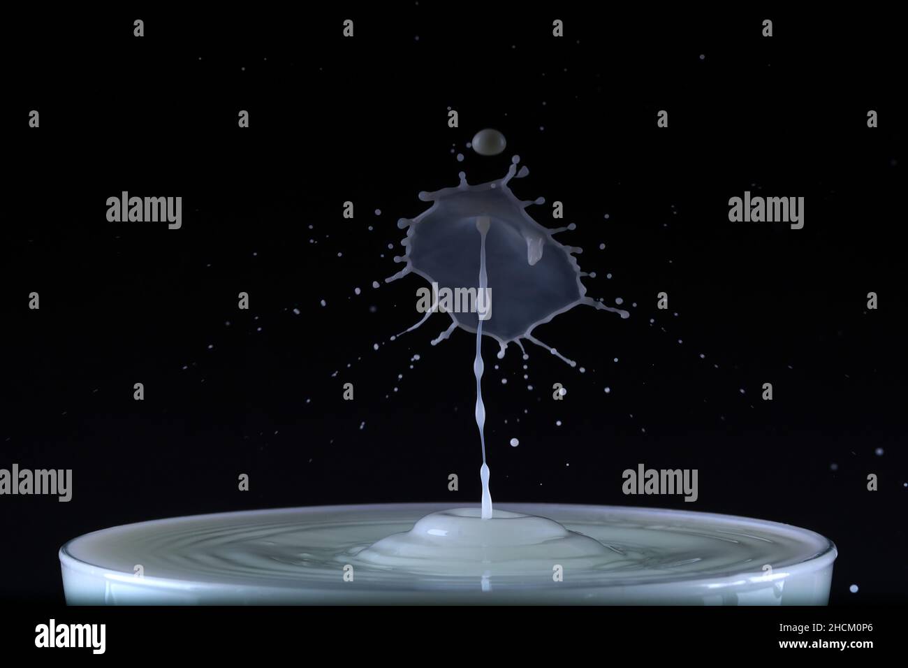 A drop of milk falls into a cup Stock Photo - Alamy