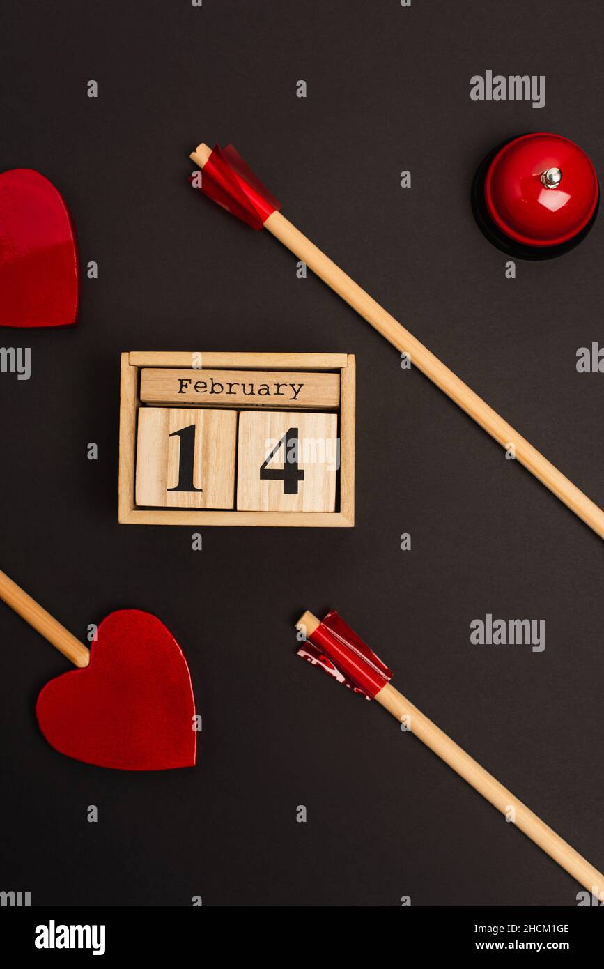 top view of heart-shaped arrows near cubes with 14 february lettering ...